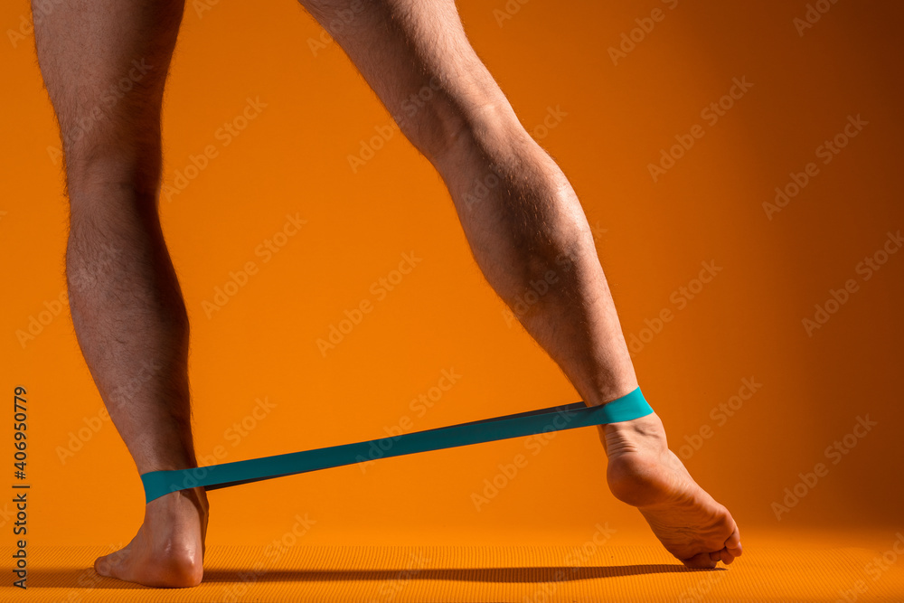 Muscular men's legs with elastic band for fitness, do exercises to ...