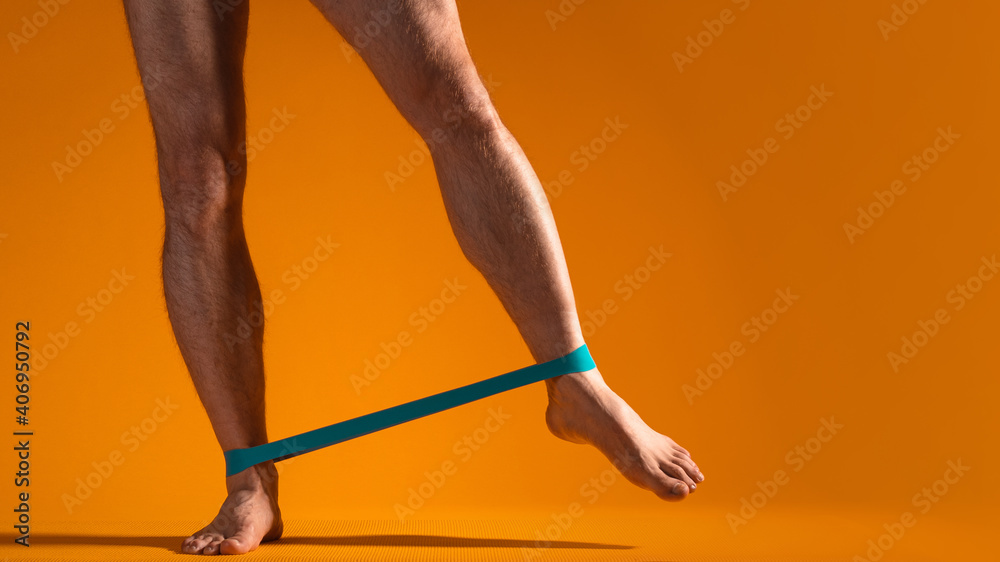 Muscular men's legs with elastic band for fitness, do exercises to ...
