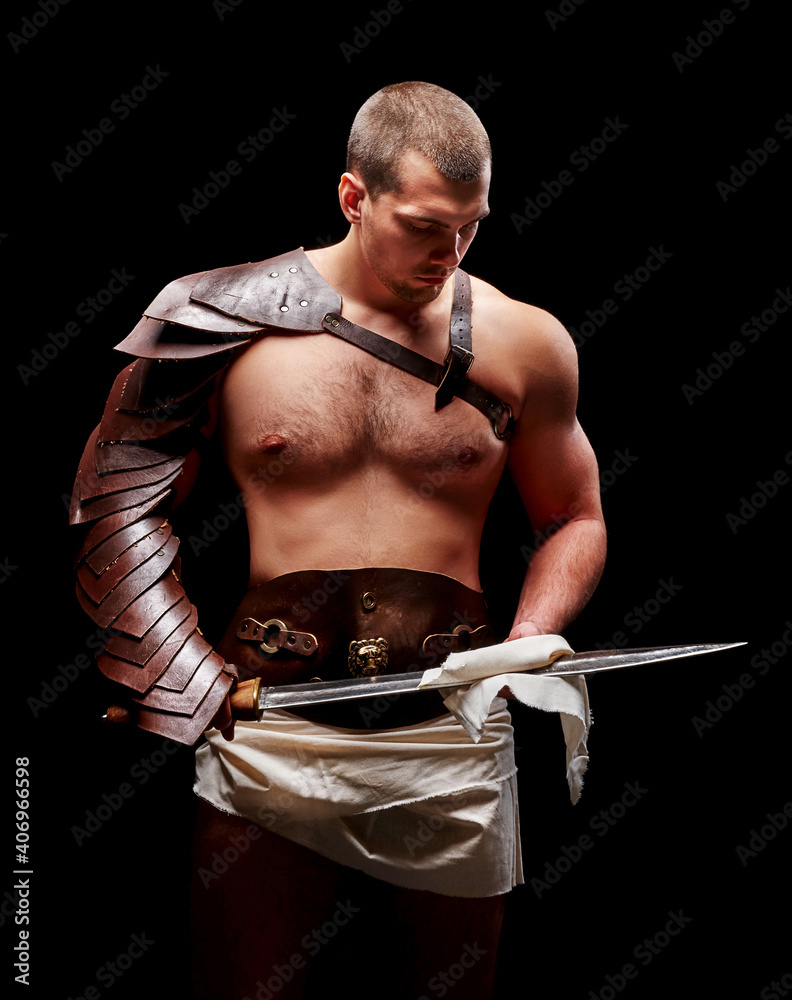 Gladiator with sword and armor on a black background. A warrior in ...