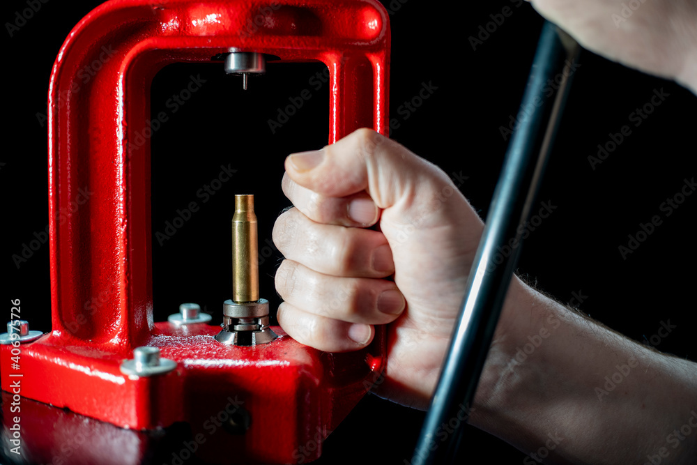 Red hand press and ammo shell against dark background, soft focus. Copy ...