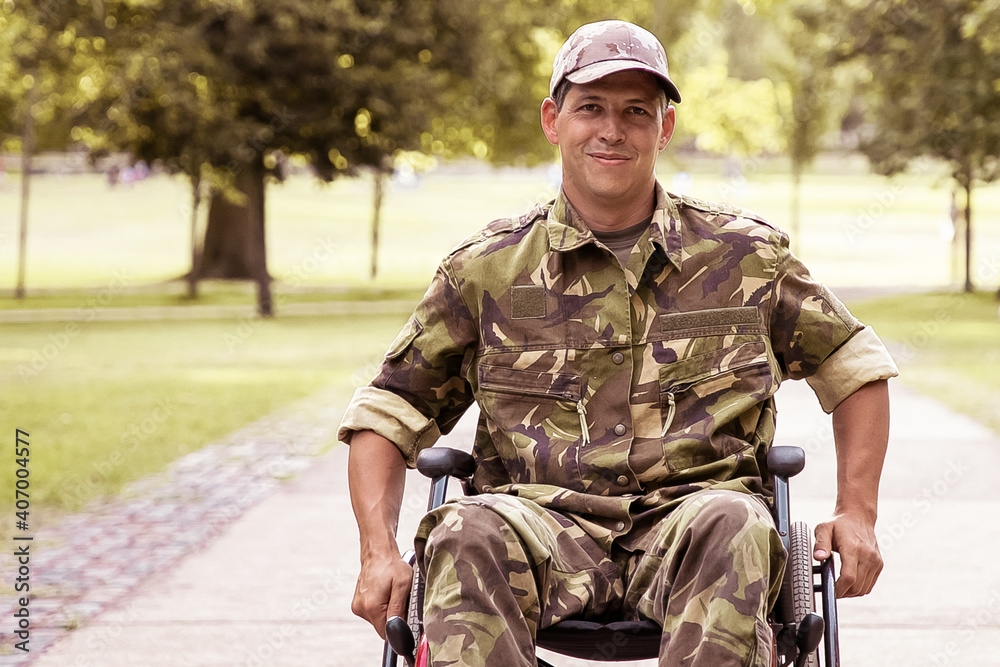 Happy disabled military man in wheelchair wearing camouflage uniform ...
