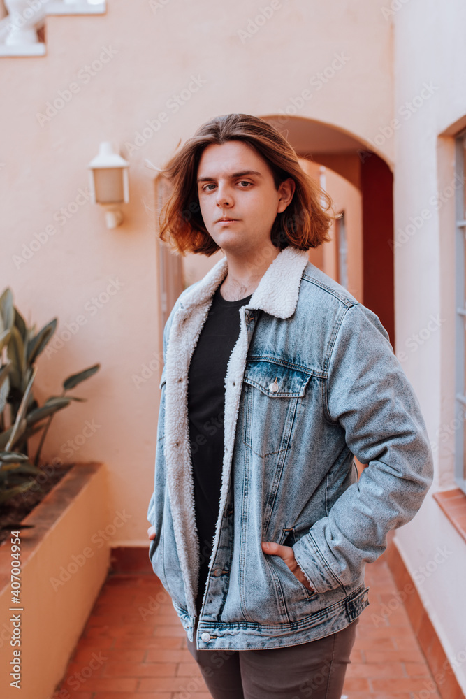 Lifestyle portrait of gen z teenage boy in denim jacket outdoors in ...