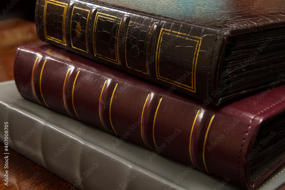 Books and photo albums in a stack. The spines are facing the camera ...