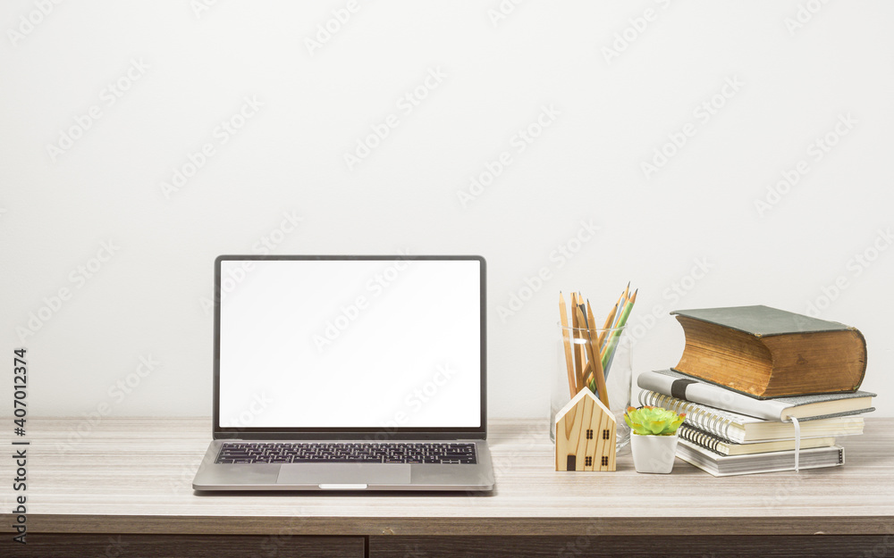 Workspace with laptop white blank screen, book and tree pot on table with living room white wall ...