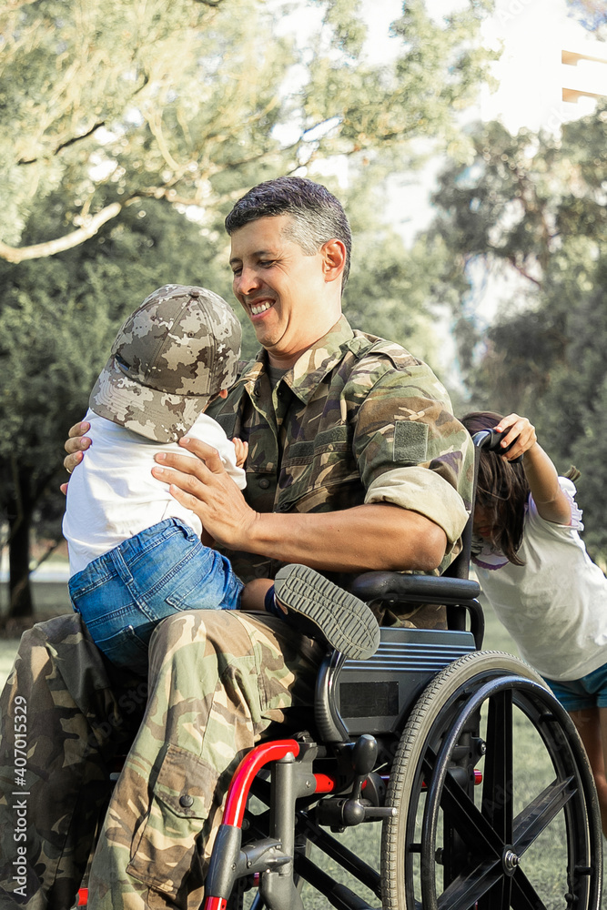 Joyful disabled military dad walking with two children in park. Girl ...