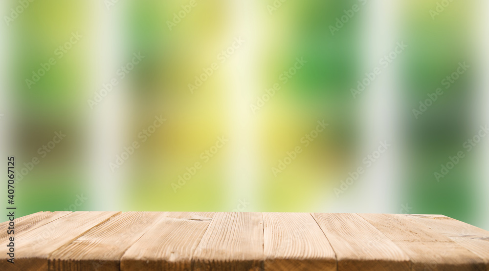 Wooden table top on blur window glass and abstract green color from ...