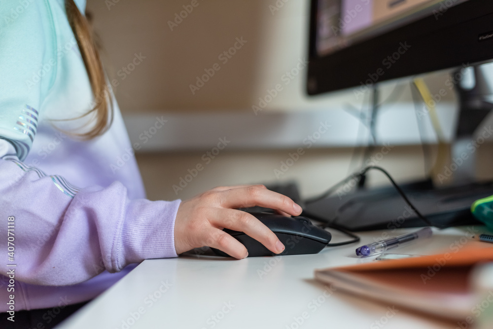 Child using a computer at home to do school work in a bedroom during ...