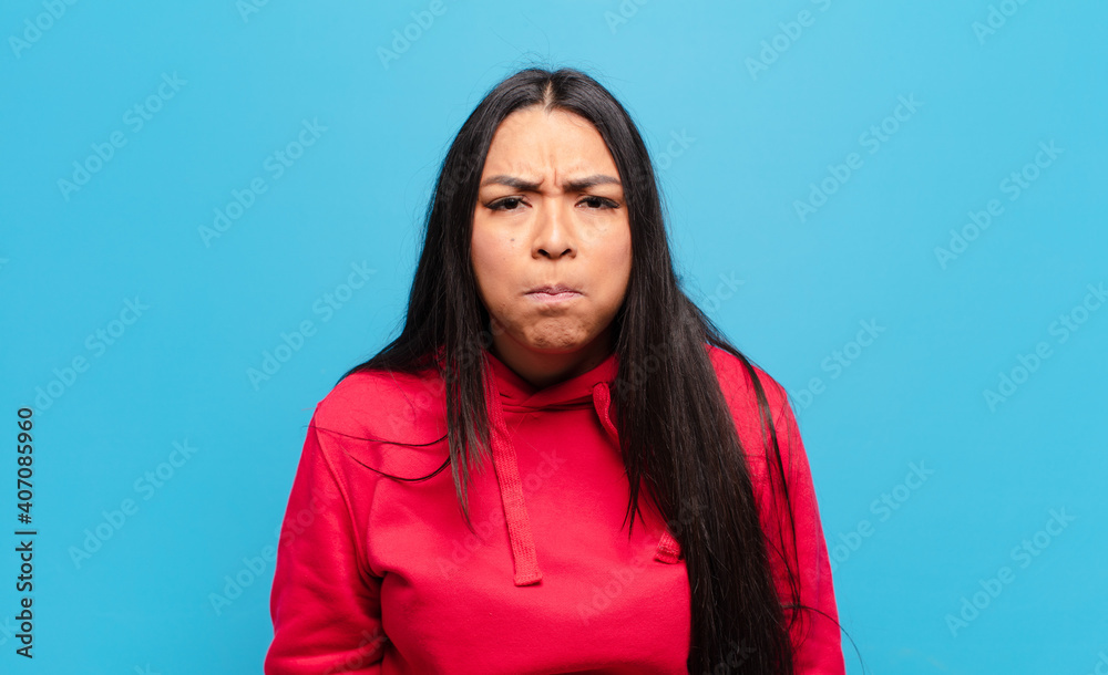 latin woman with a goofy, crazy, surprised expression, puffing cheeks ...