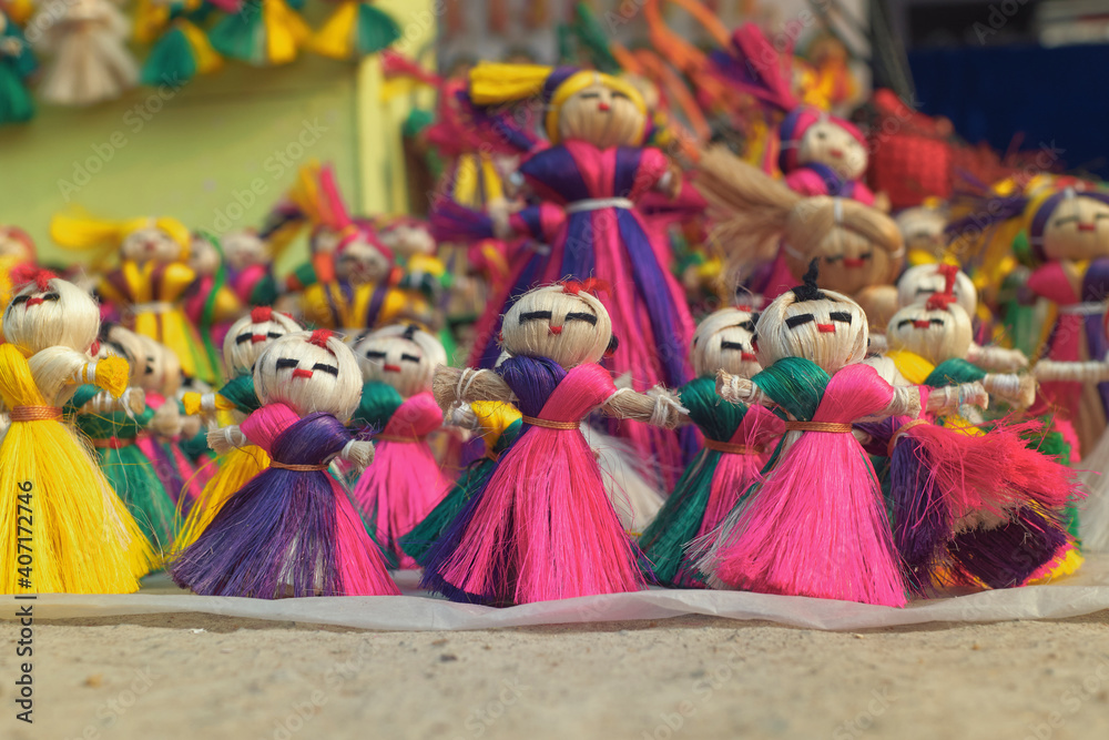 Vibrant multicolor jute dolls, used as wall hanging puppets in a retail ...