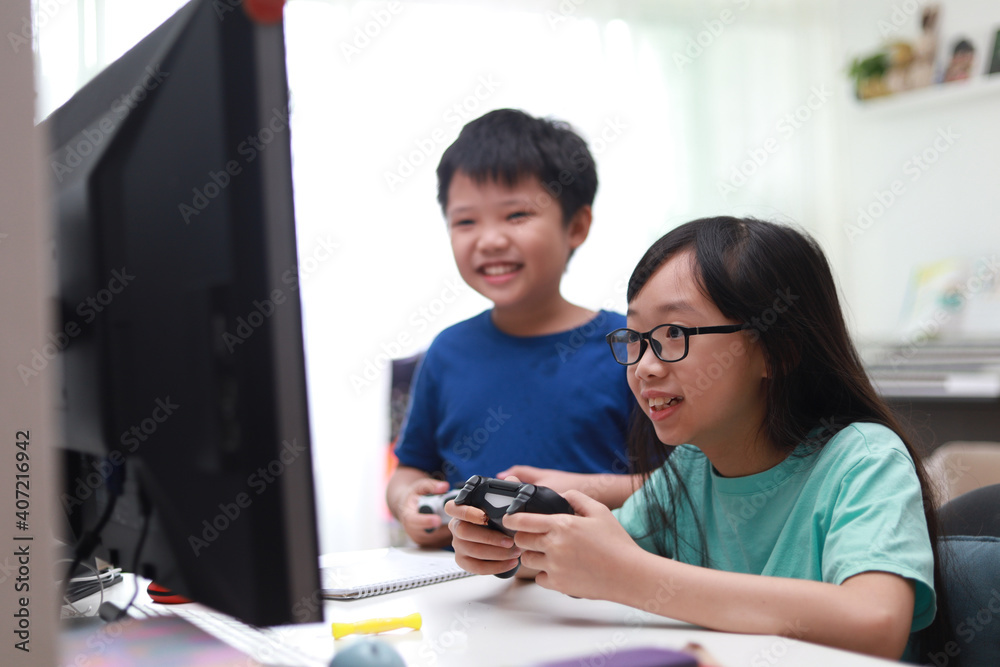 Boy and girl sitting in the living room playing a video game in front ...