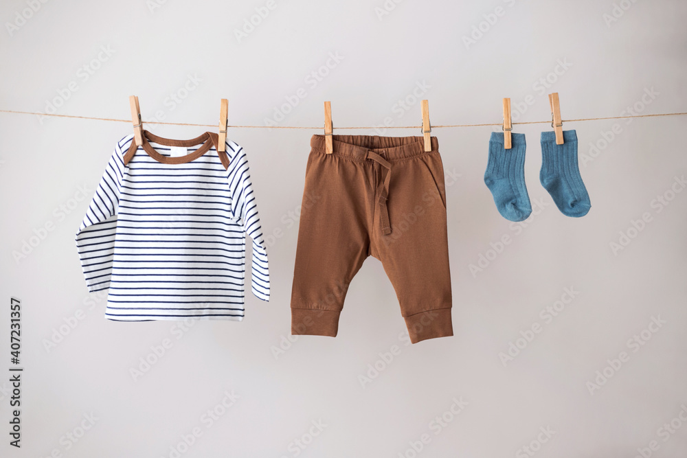 Baby clothes hanging on the rope. Stock Photo | Adobe Stock