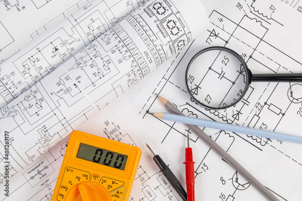 paper electrical engineering drawings, pencil, magnifying glass and ...