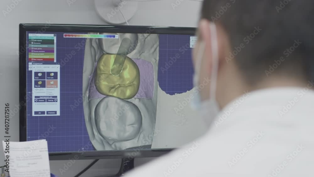 Stockvideon Doctor dentist works on a computer in a 3D program. Creates ...