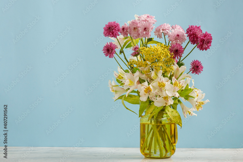 Florero amarillo con flores de diferentes tipos y colores sobre una ...
