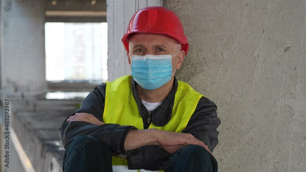 Vidéo Stock Workman in yellow hard hat and medical protective face mask ...