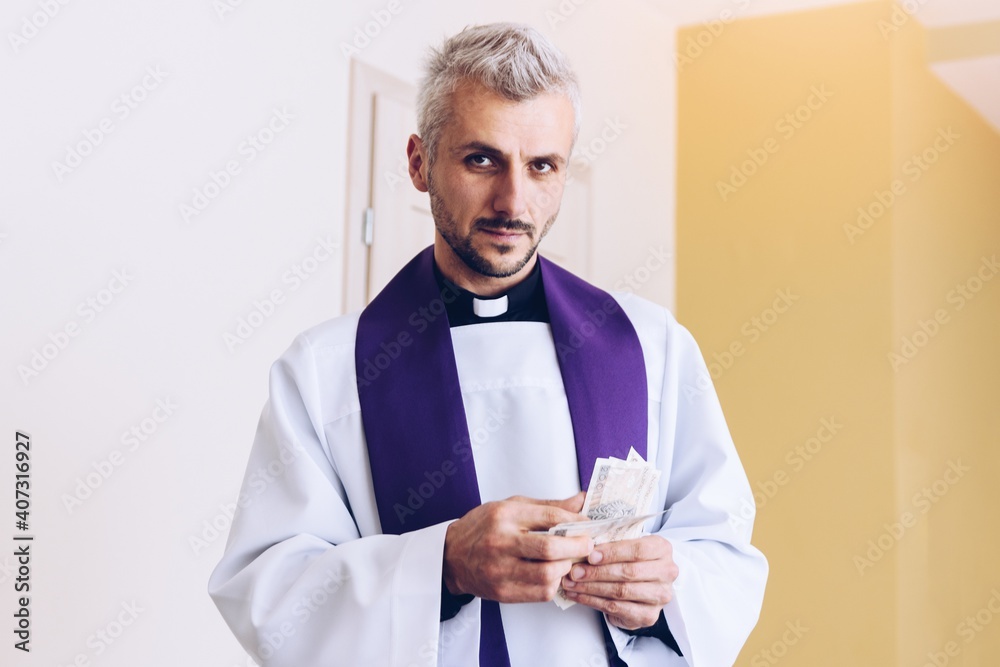 Polish catholic priest holding and counting money during pastoral visit ...