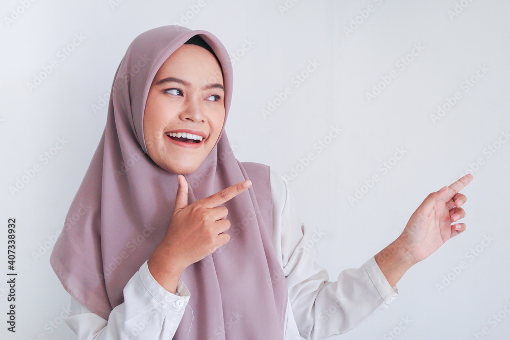 Asian Islam Muslim woman wearing headscarf is pointing finger to blank ...
