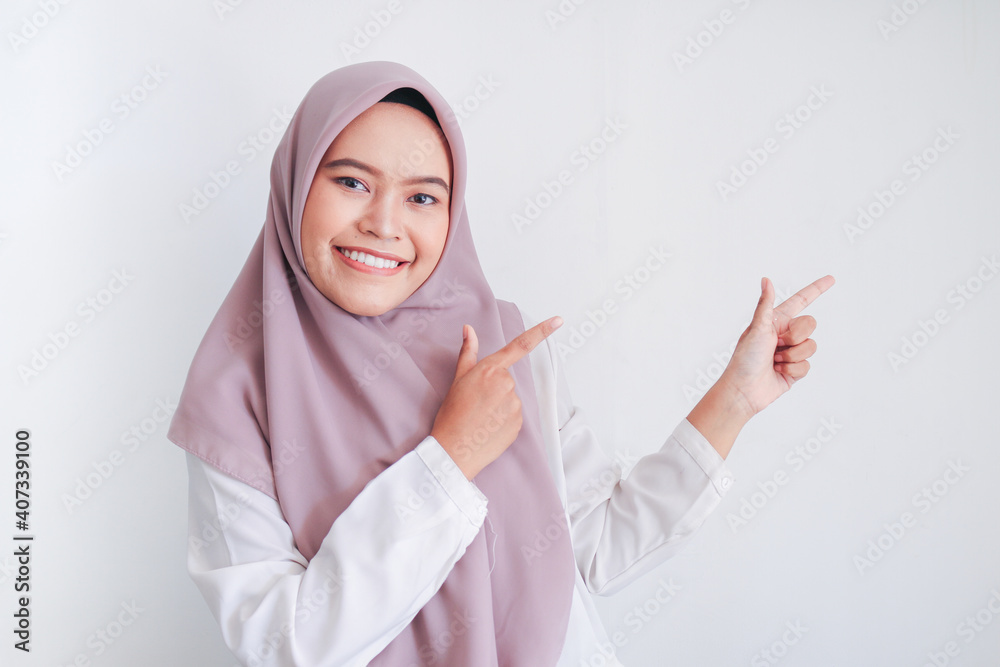 Asian Islam Muslim woman wearing headscarf is pointing finger to blank ...