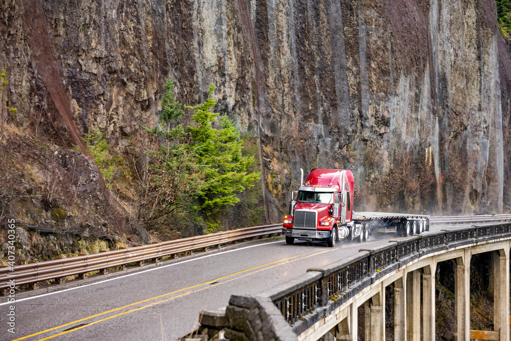 Industrial big rig red semi truck with empty flat bed semi trailer ...