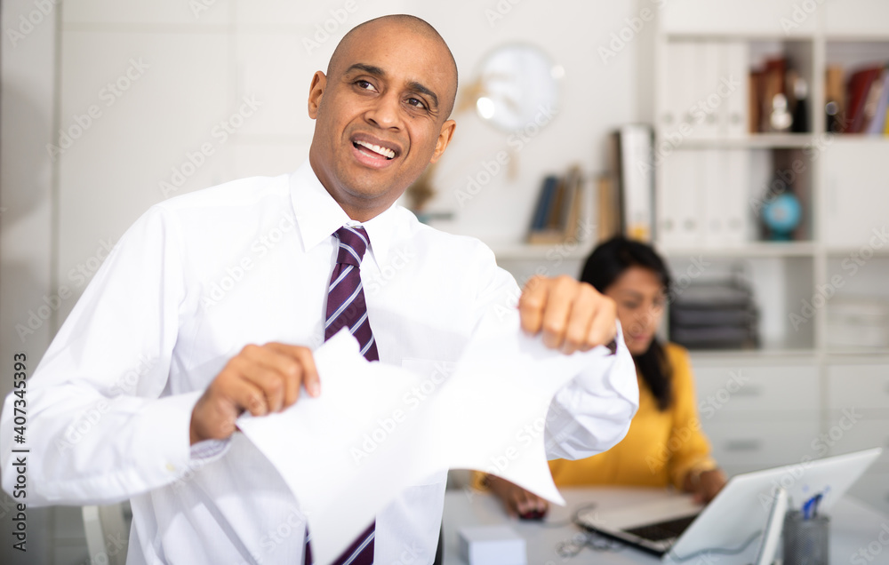Enraged man tearing piece of paper, trying to calm down after setback ...
