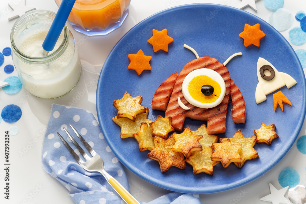 Cute smiling alien shaped hamburger served with roast potatoes, carrots ...