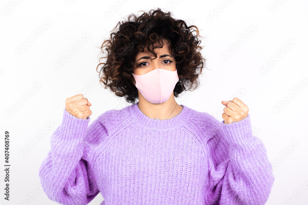 Irritated young beautiful caucasian woman wearing medical mask standing ...