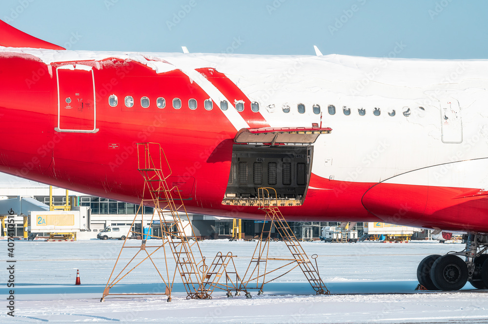 Winter scene of the airport. Modern twin-engine cargo airplane stand at ...