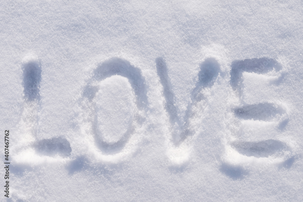 Inscription Love on a fluffy snow. Man expressing his feelings to a ...