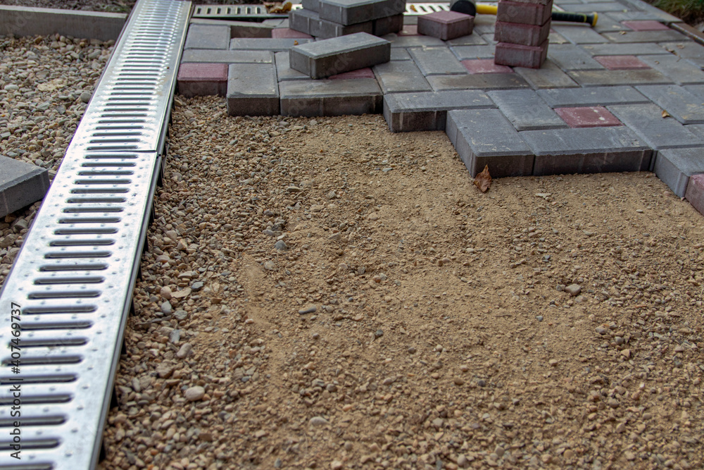 Gutter, drain for water after rain on the sidewalk. Installation of ...