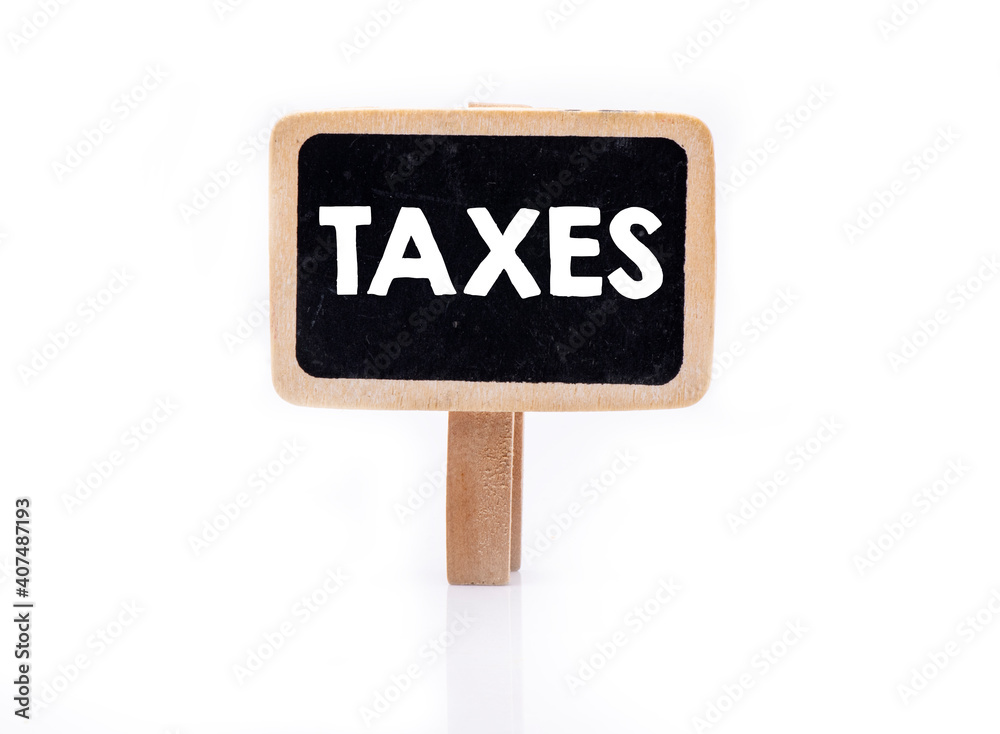 TAXES word on small chalkboard and white background. Concept for ...