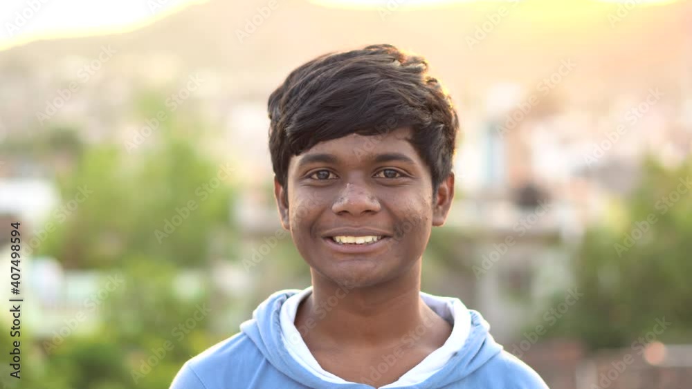 Closeup portrait of an Indian kid smiling while looking at the camera ...
