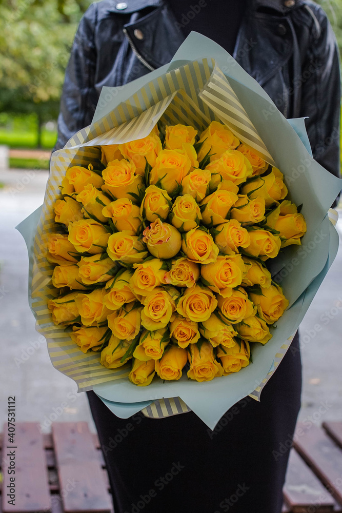 Big bouquet of yellow roses in woman hands, girl in black holding ...