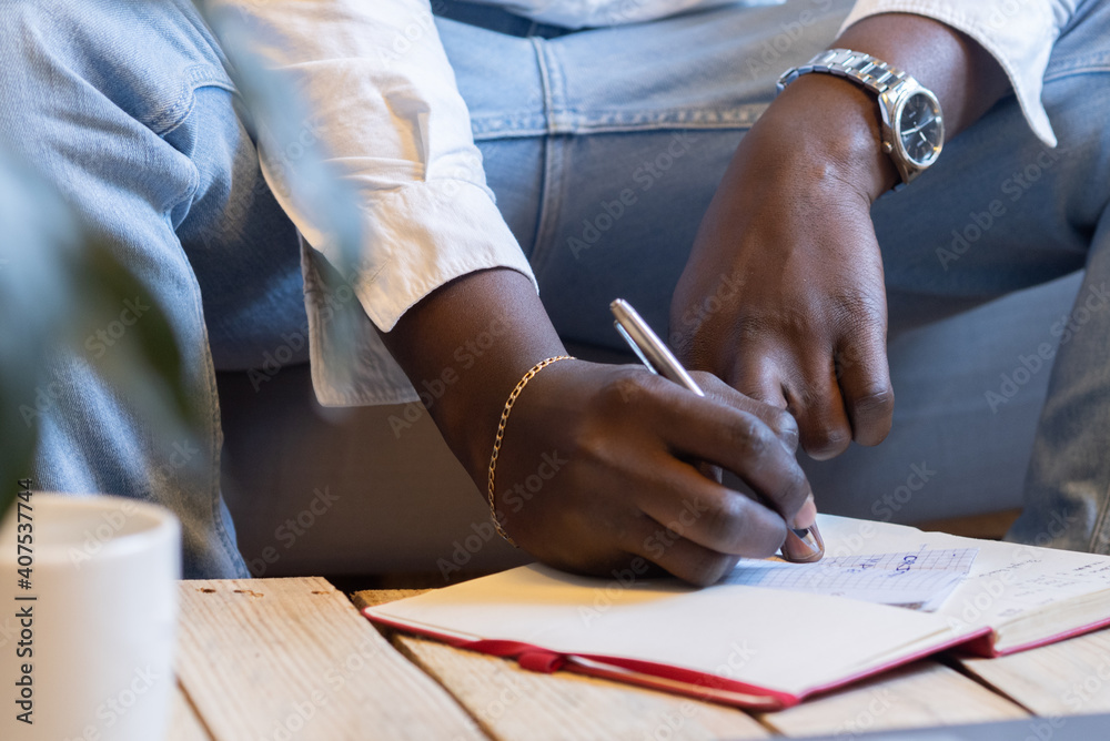 Afro man hands writing with a pen on a notepad in an office Stock Photo ...