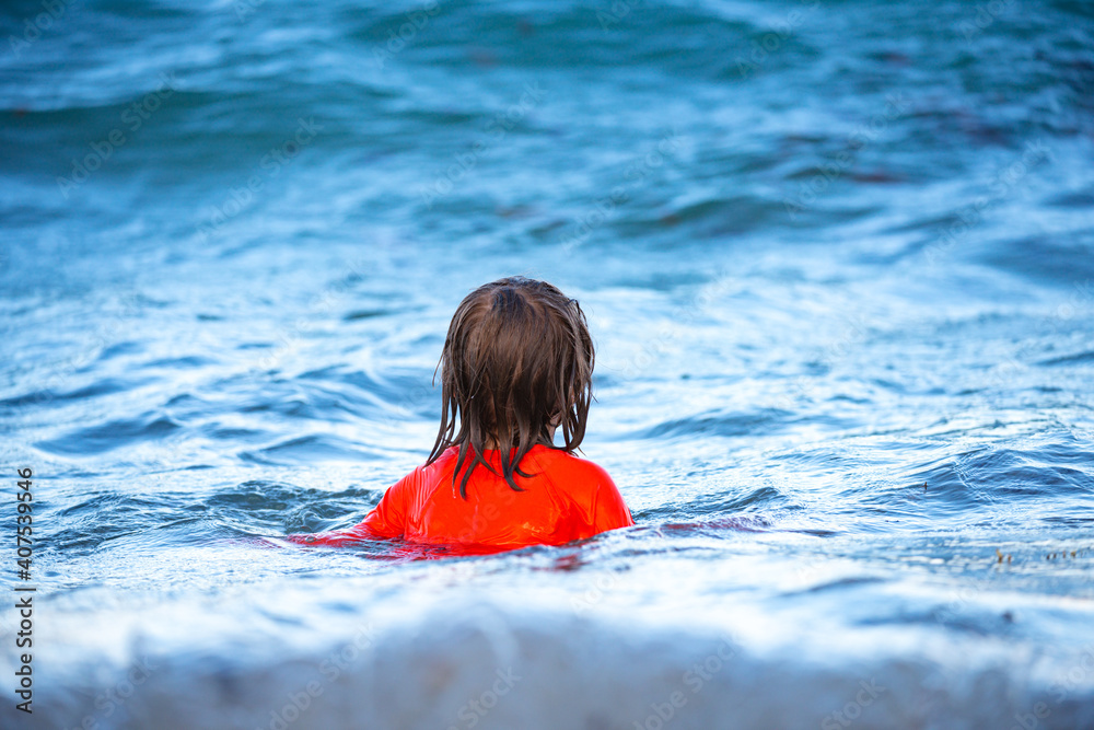Happy child playing in the sea. Little boy swimming on Waves at sea ...