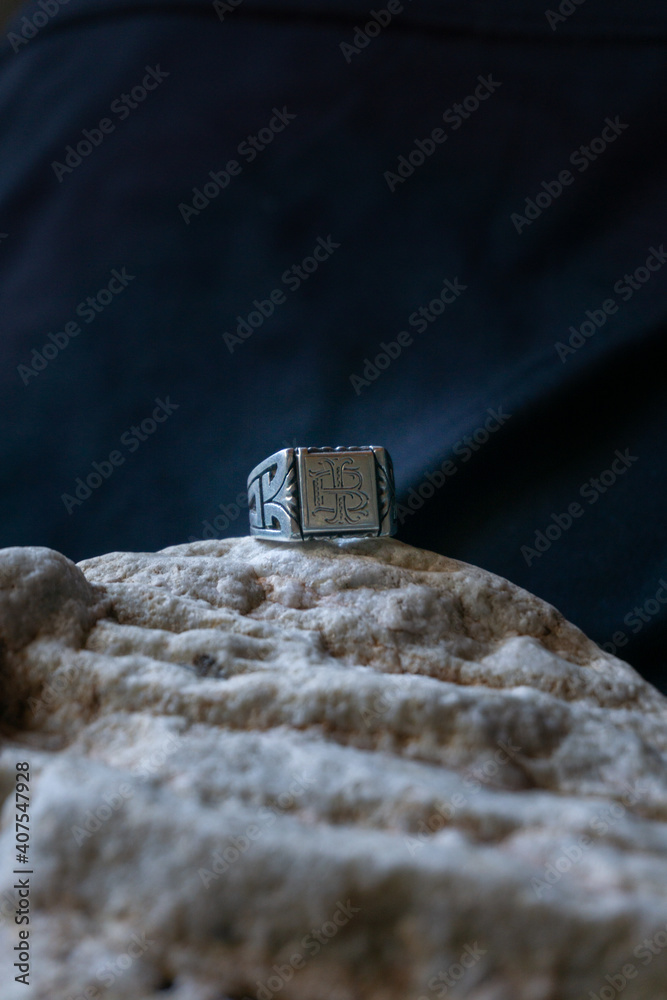 Silver ring with a dark fabric background, the ring has a background ...