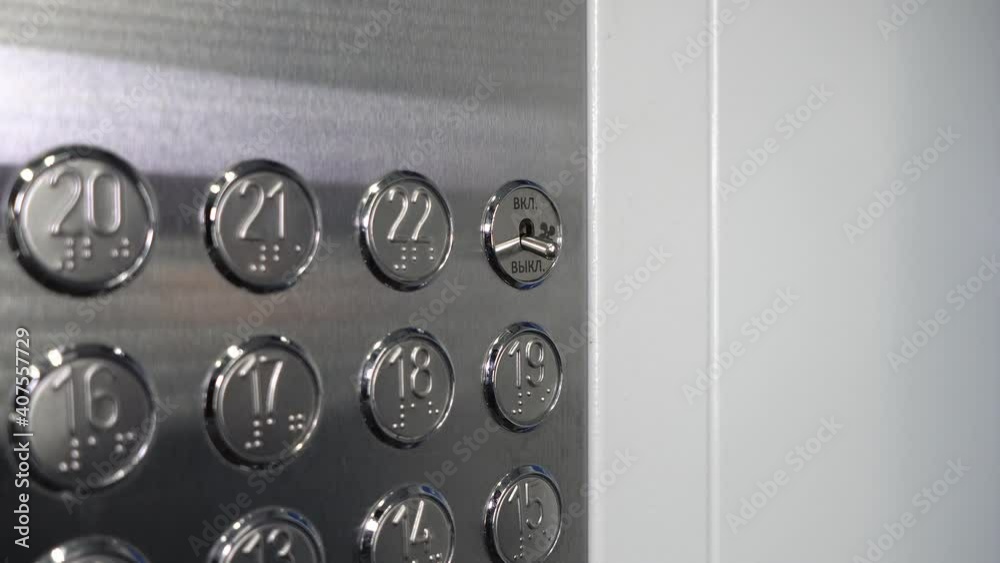 A female hand presses a button in the elevator. The girl turns on and ...