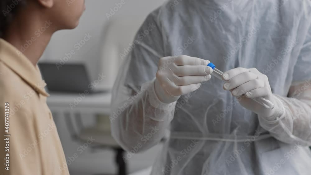 Unrecognizable medical worker wearing protection suit and gloves taking ...