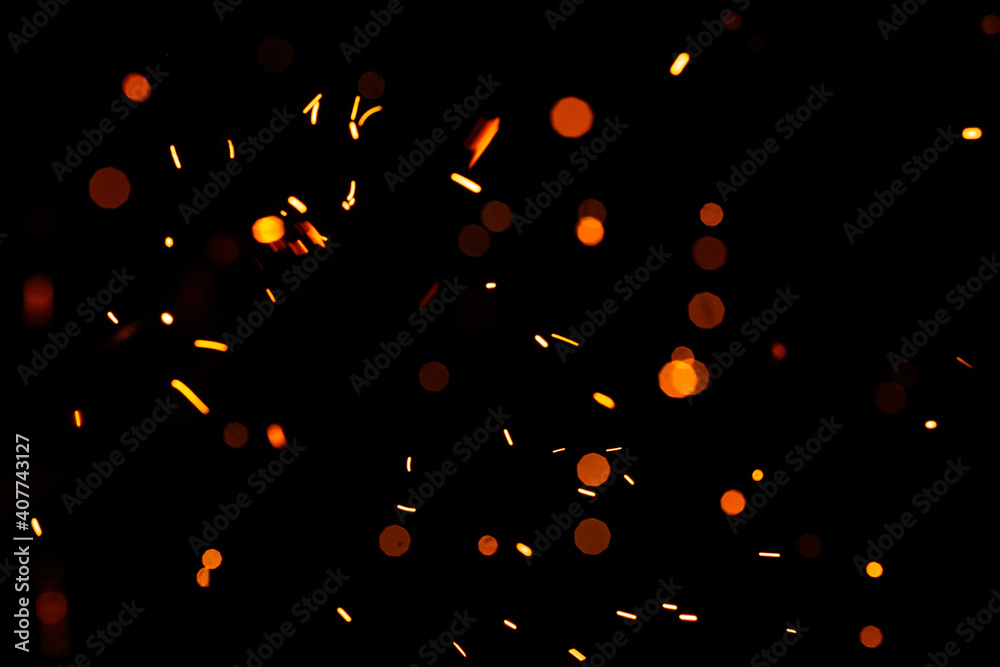 Particles of burning embers fly and glow isolated in the night sky ...