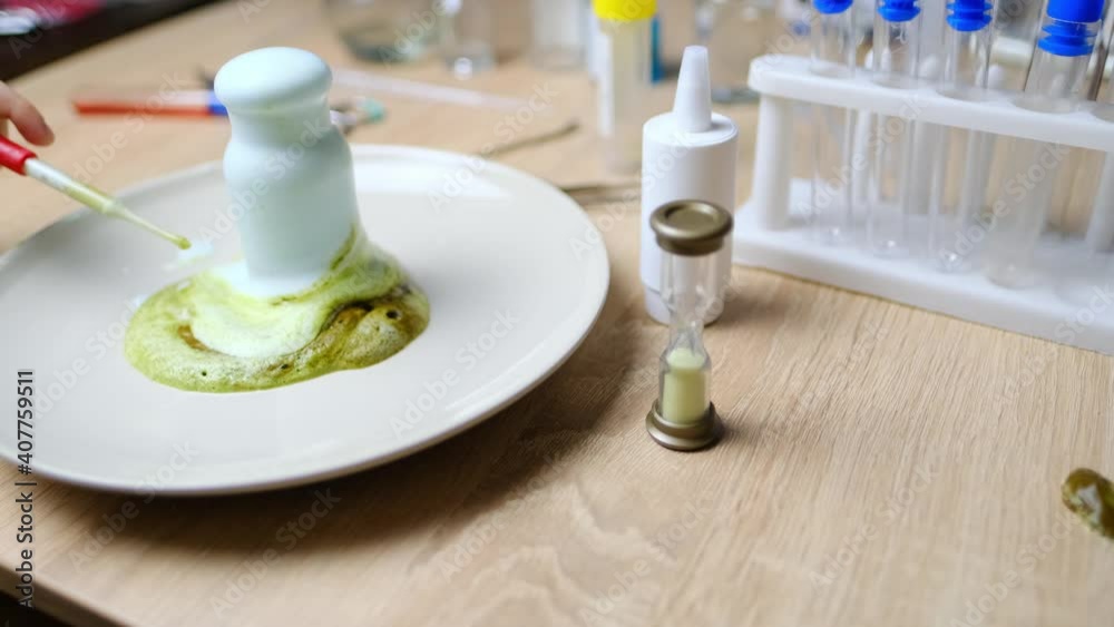 children, elementary school boys, pour colored liquids into glass ...