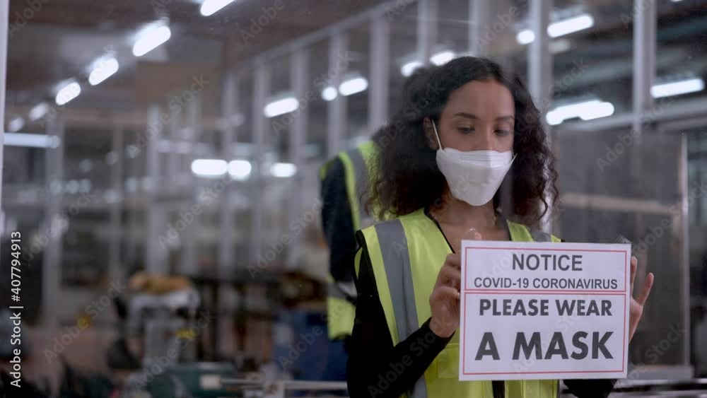 Video Stock woman factory worker holding the signage of wear a face ...