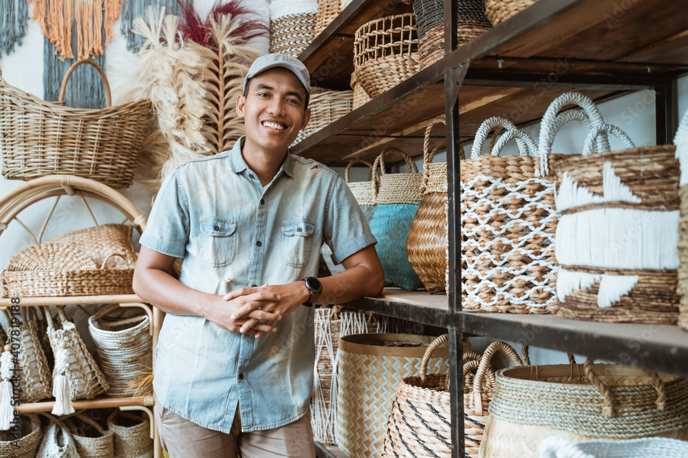 handicraft business owner with his hands leaning back on a shelf while ...