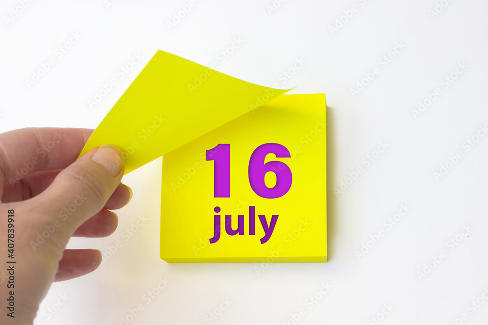 July 16th. Day 16 of month, Calendar date. Hand rips off the yellow ...