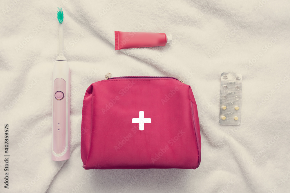 First aid kit bag, ultrasonic electric toothbrush and tube of ...