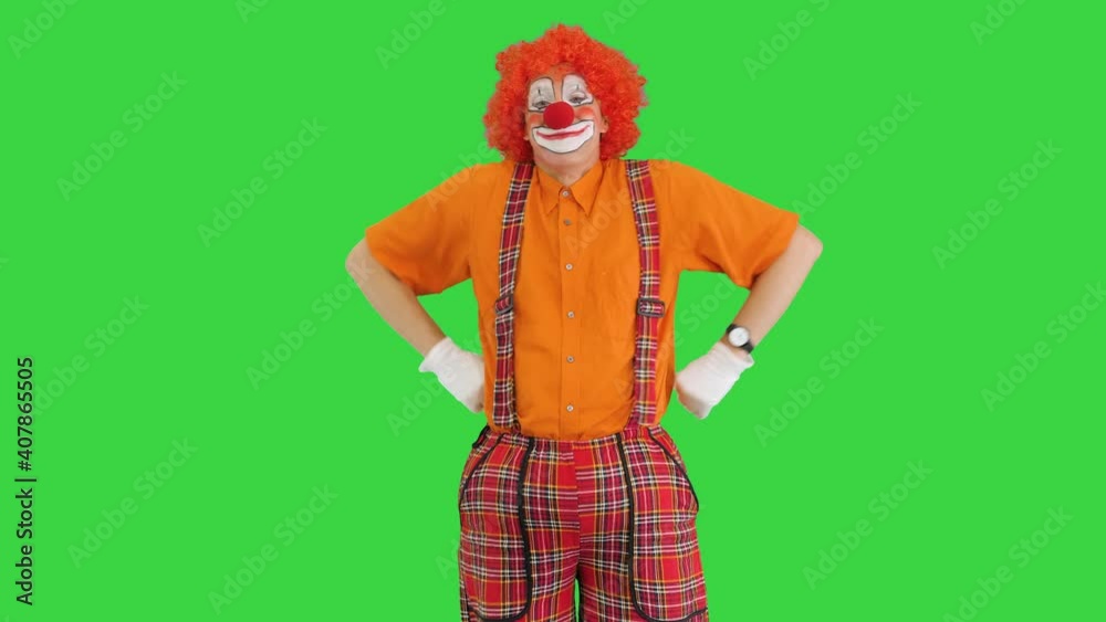 Male clown yawning and doing some exercise in the morning on a Green ...