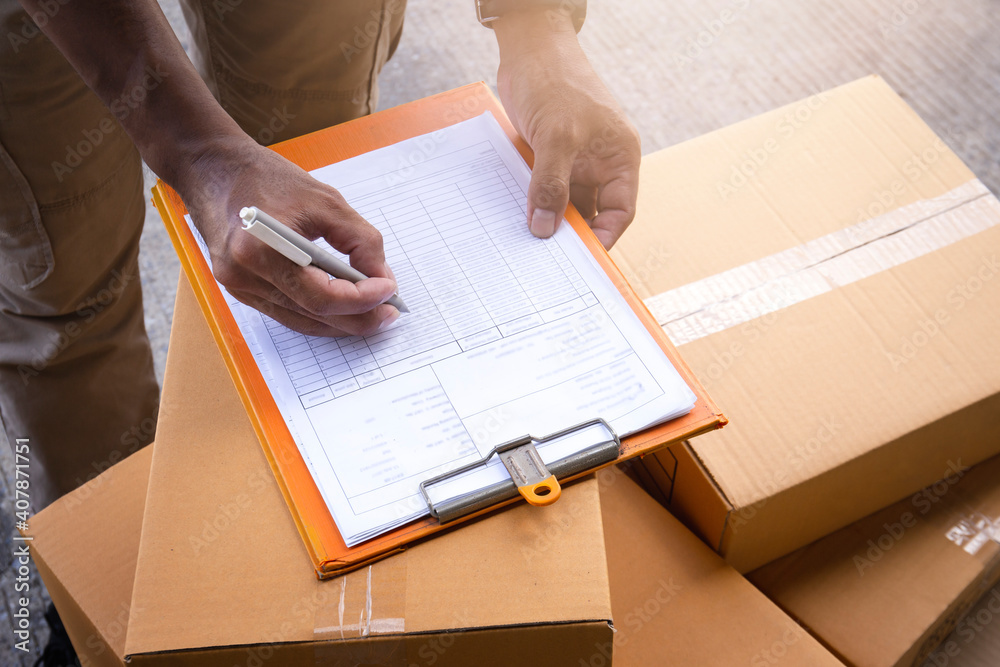 Warehouse worker writing paper on clipboard. inventory management of ...