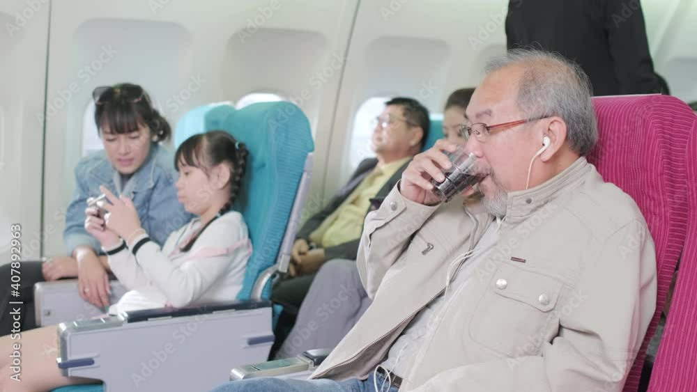 Vidéo Stock Stewardess or cabin attendance serve food and drink to senior passenger on the ...