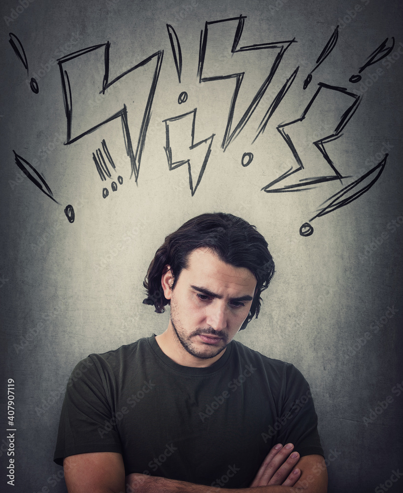 Annoyed man makes a displeased facial expression, arms crossed looking ...