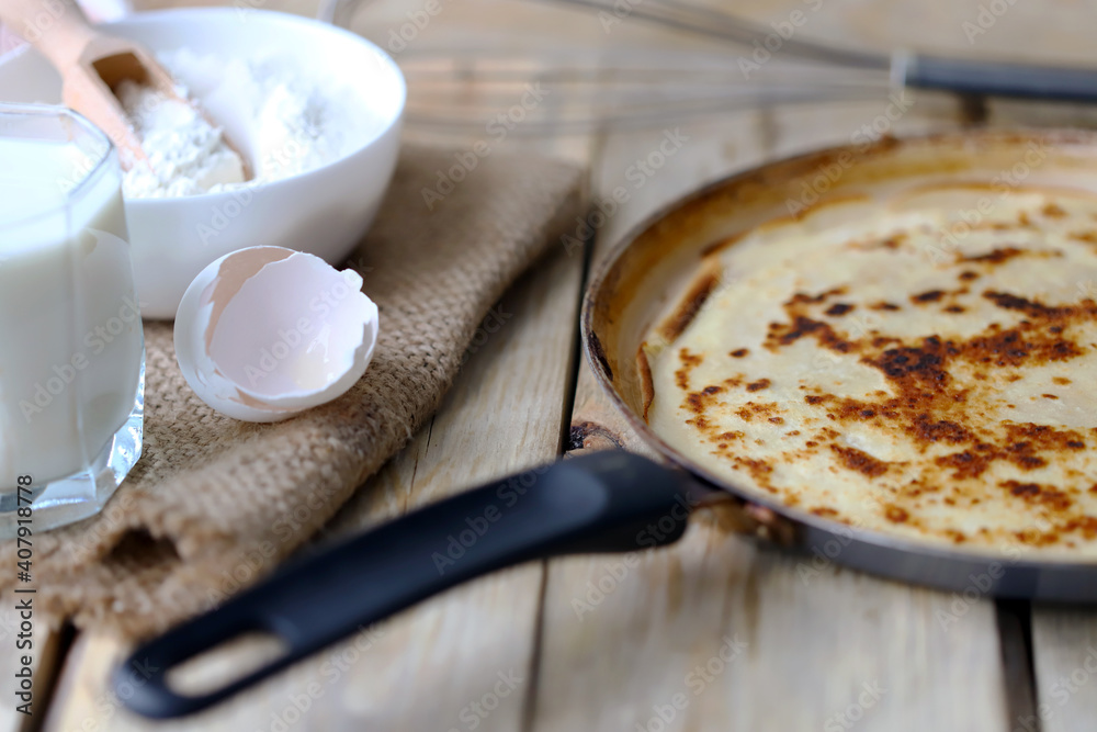 Frying pan with pancake, flour, milk, eggs. Pancake making concept ...