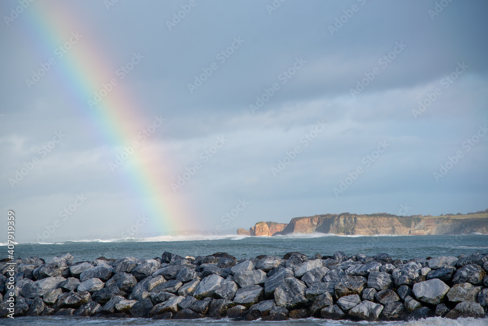 Foto de Arcoiris en un cielo azul nublado con el mar de fondo en ...
