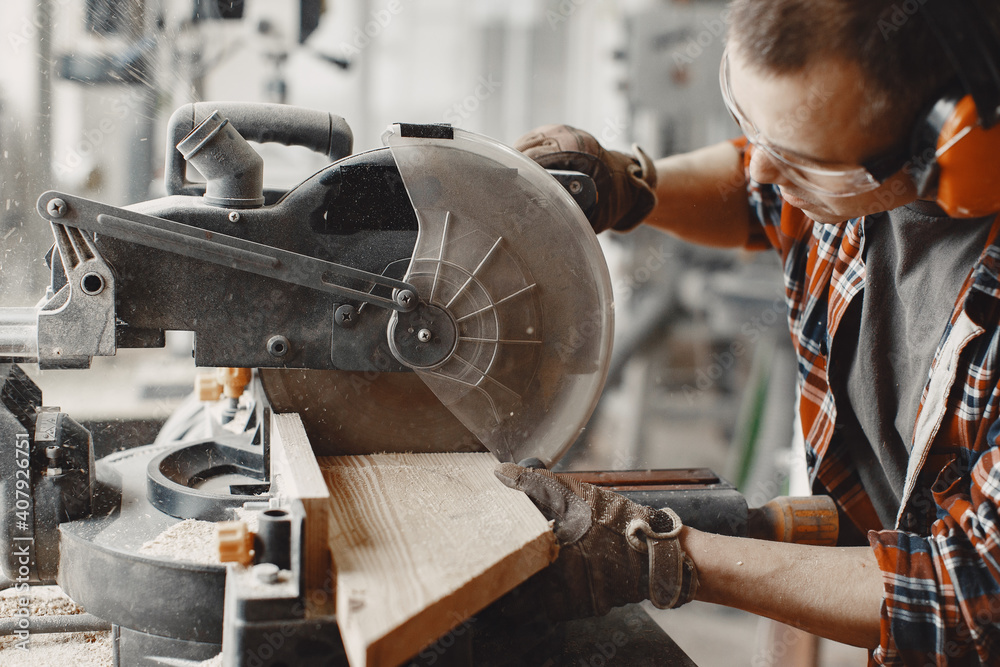 Wood cutting with circular saw. Closeup of mature man sawing lumber ...